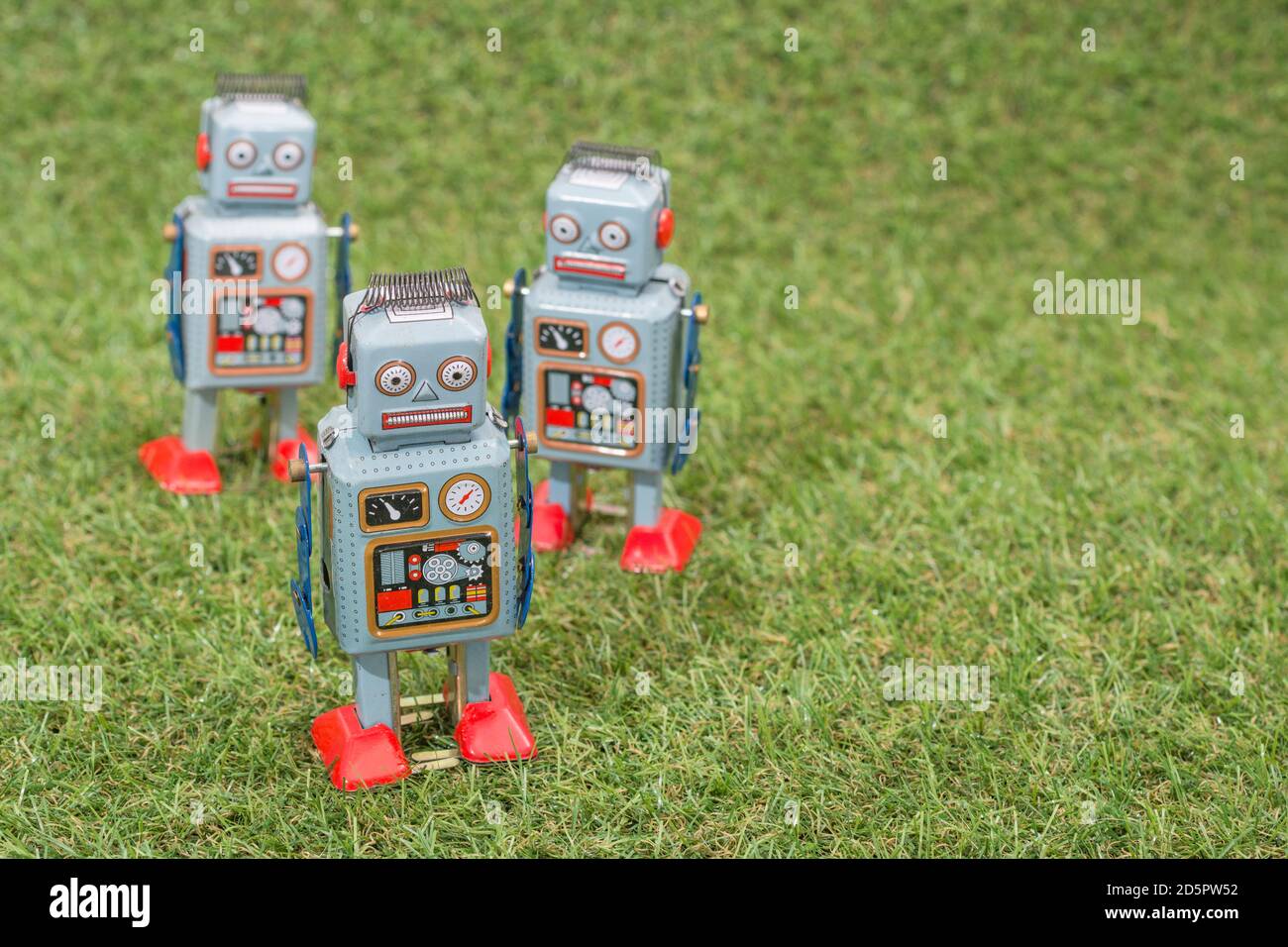 Wind-up clockwork toy robot on fake grass. For troll farm, Russian bots ...