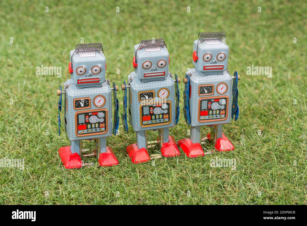 Wind-up clockwork toy robot on fake grass. For troll farm, Russian bots ...