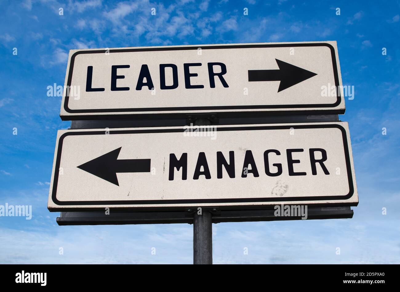 Leader vs manager. White two street signs with arrow on metal pole with ...