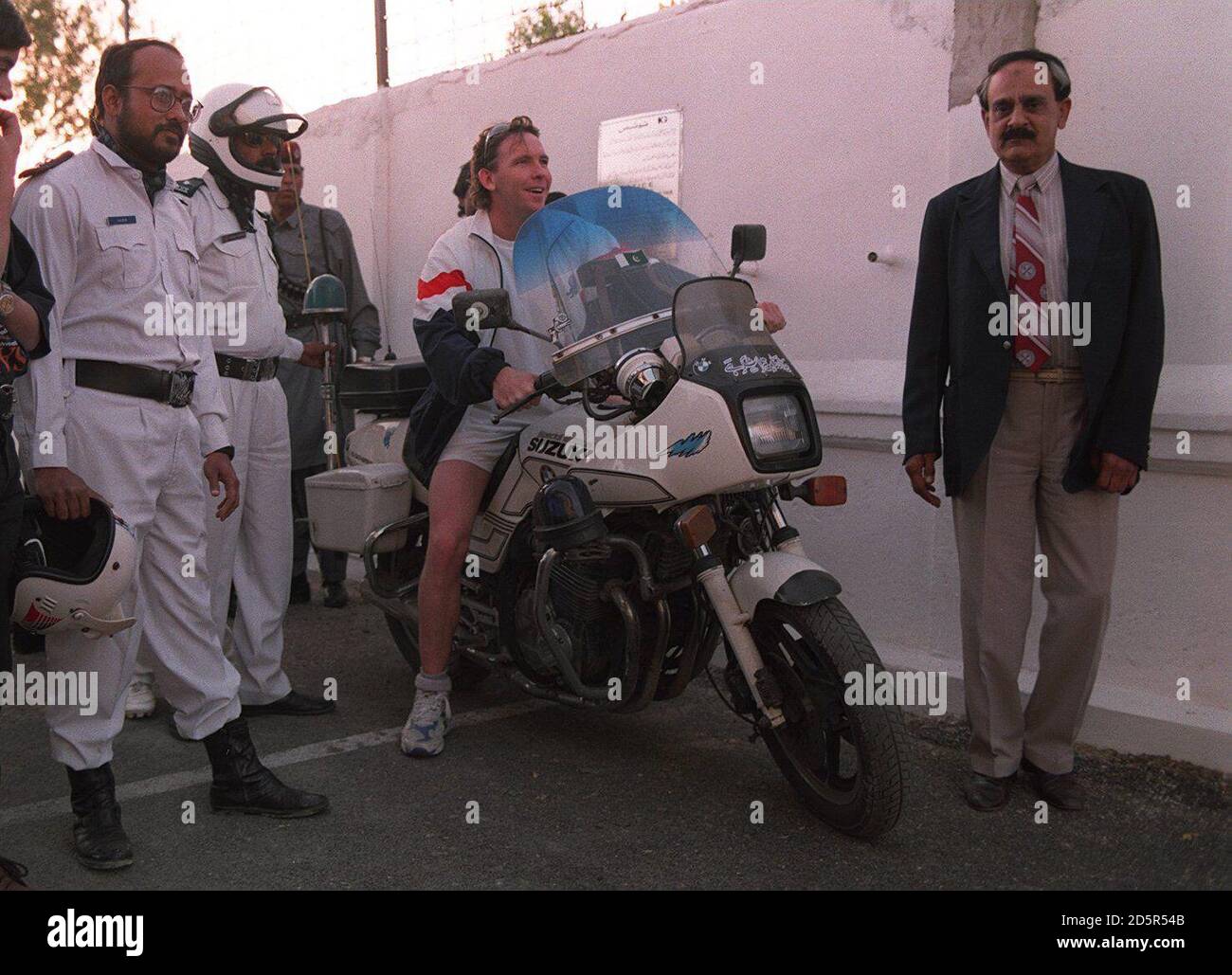 Dermot Reeve (centre) goes for a ride on a police motorbike after nets ...