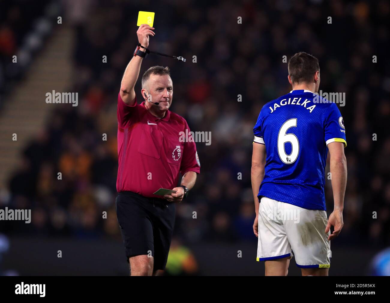 Everton's Phil Jagielka is shown a yellow card by referee Jon Moss ...
