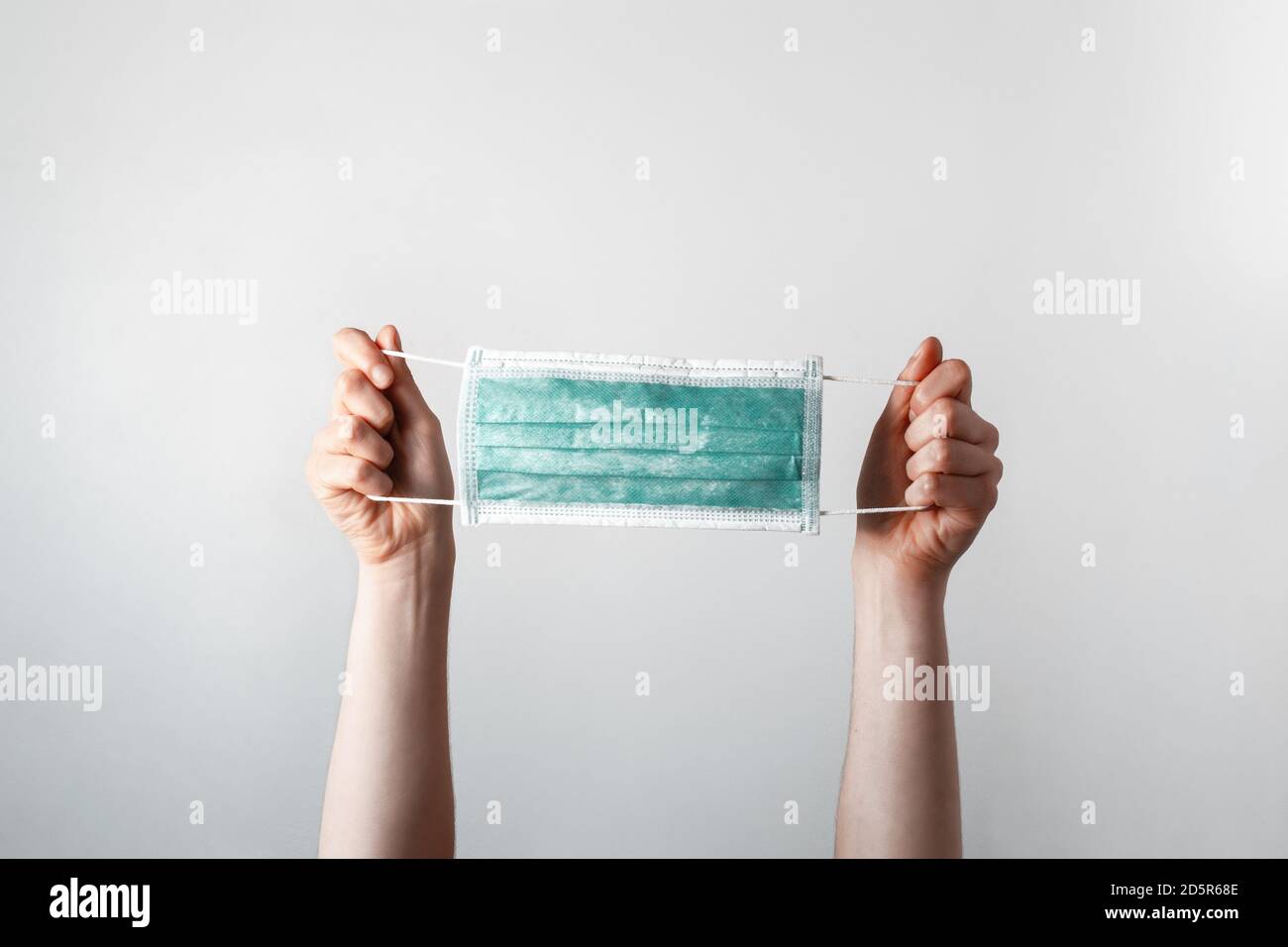 Closeup of hands holding a mask - a call for wearing a face mask to ...