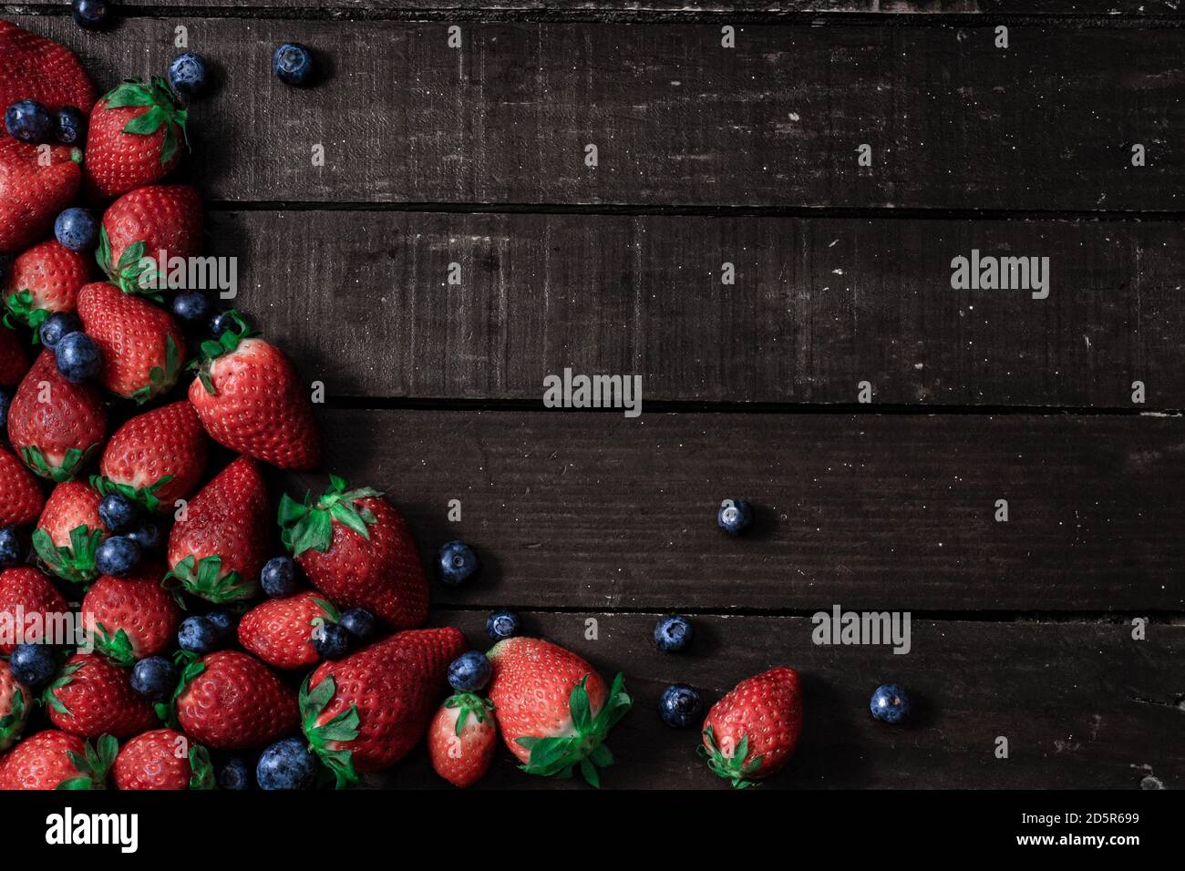 Flat lay of strawberries and blueberries on the left bottom corner ...