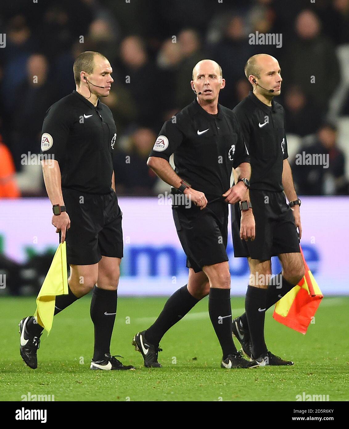 Referee Mike Dean (centre) leaves the pitch at half-time with ...