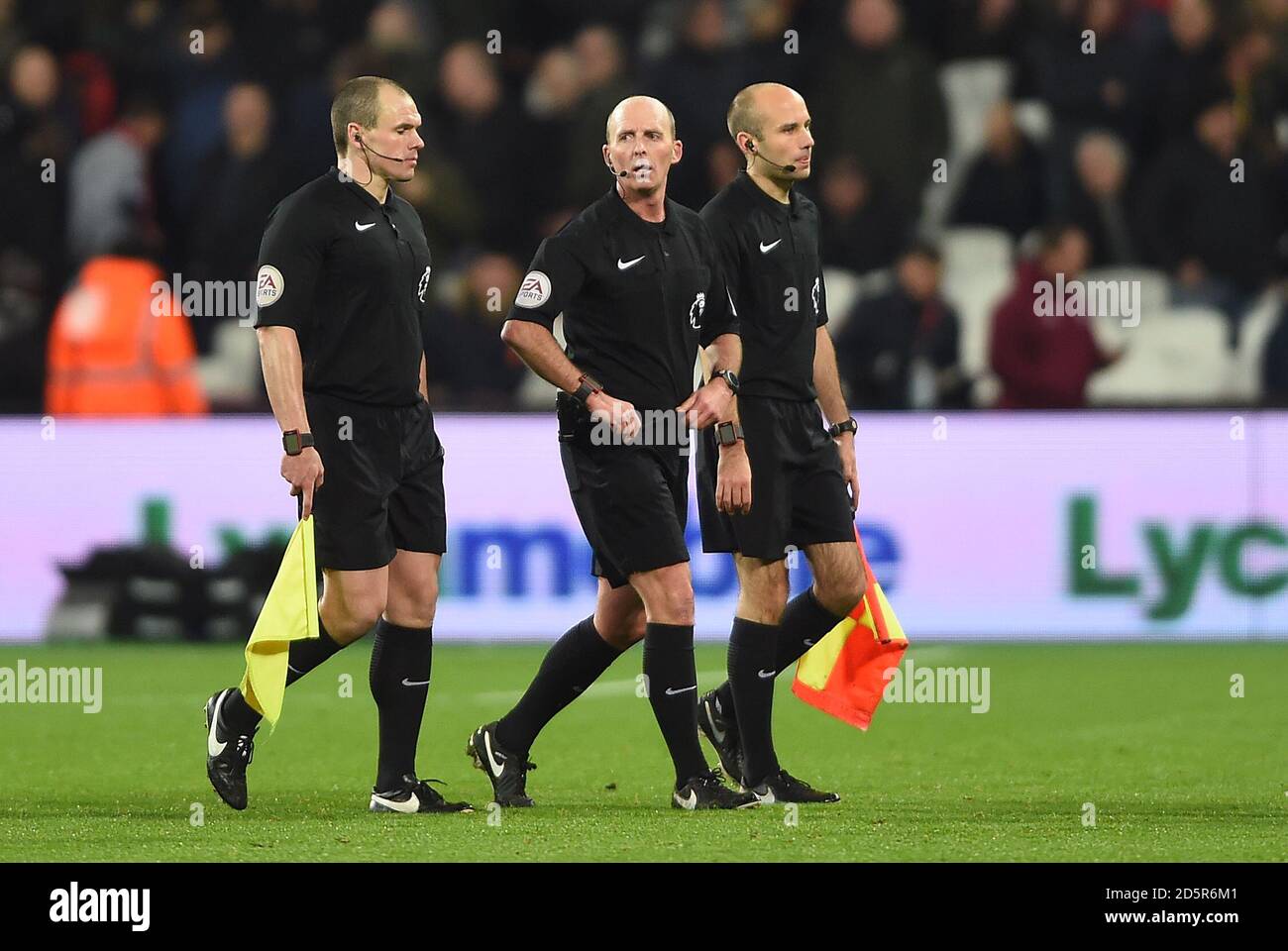 Referee Mike Dean (centre) leaves the pitch at half-time with ...