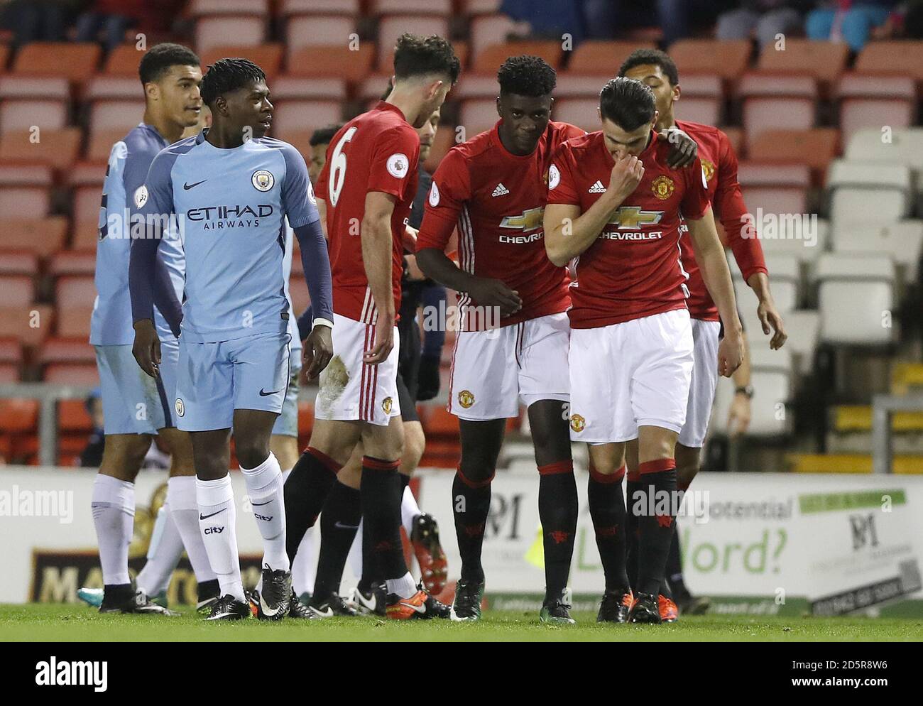 Manchester United's Regan Poole (right) after being shown the red card ...