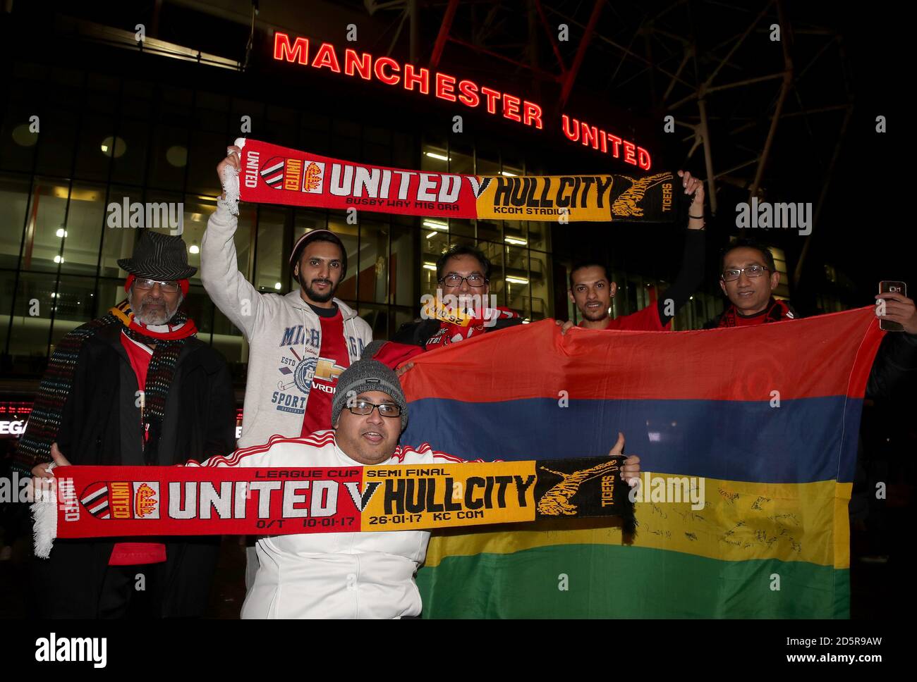 Fans outside the stadium hold up half and half scarves ahead of the ...