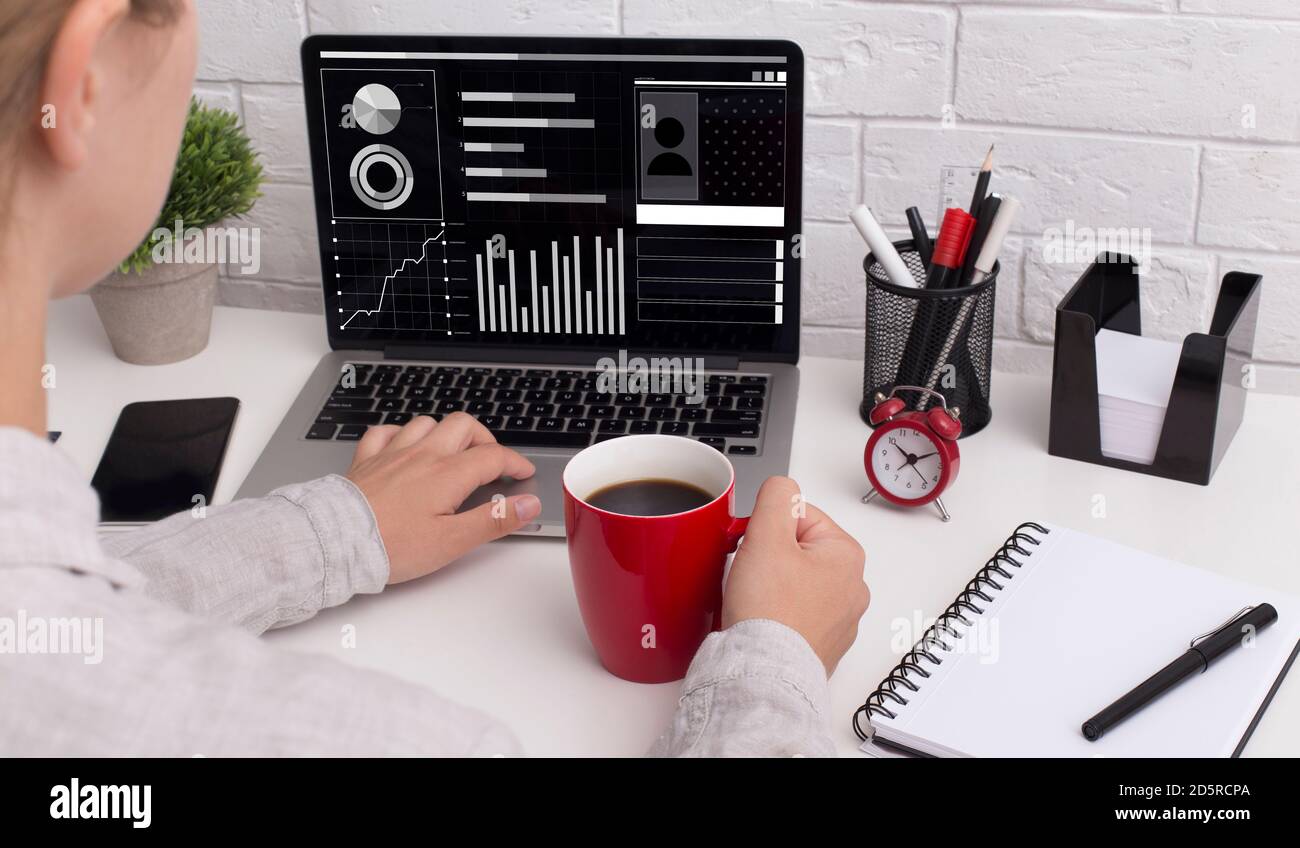 Female financial analyst working on laptop at office, studying ...