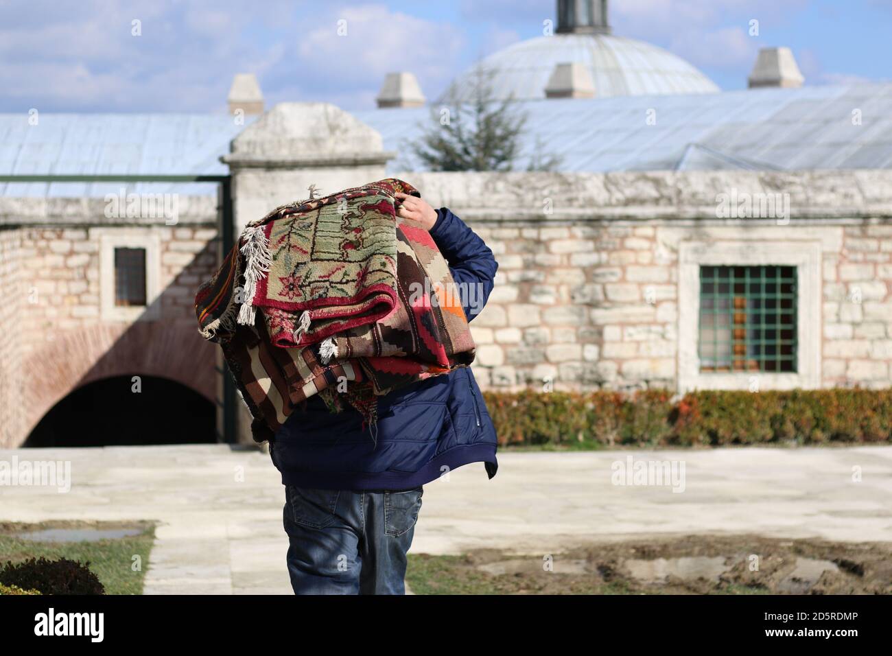 workingman carrying a lot of carpets Stock Photo - Alamy