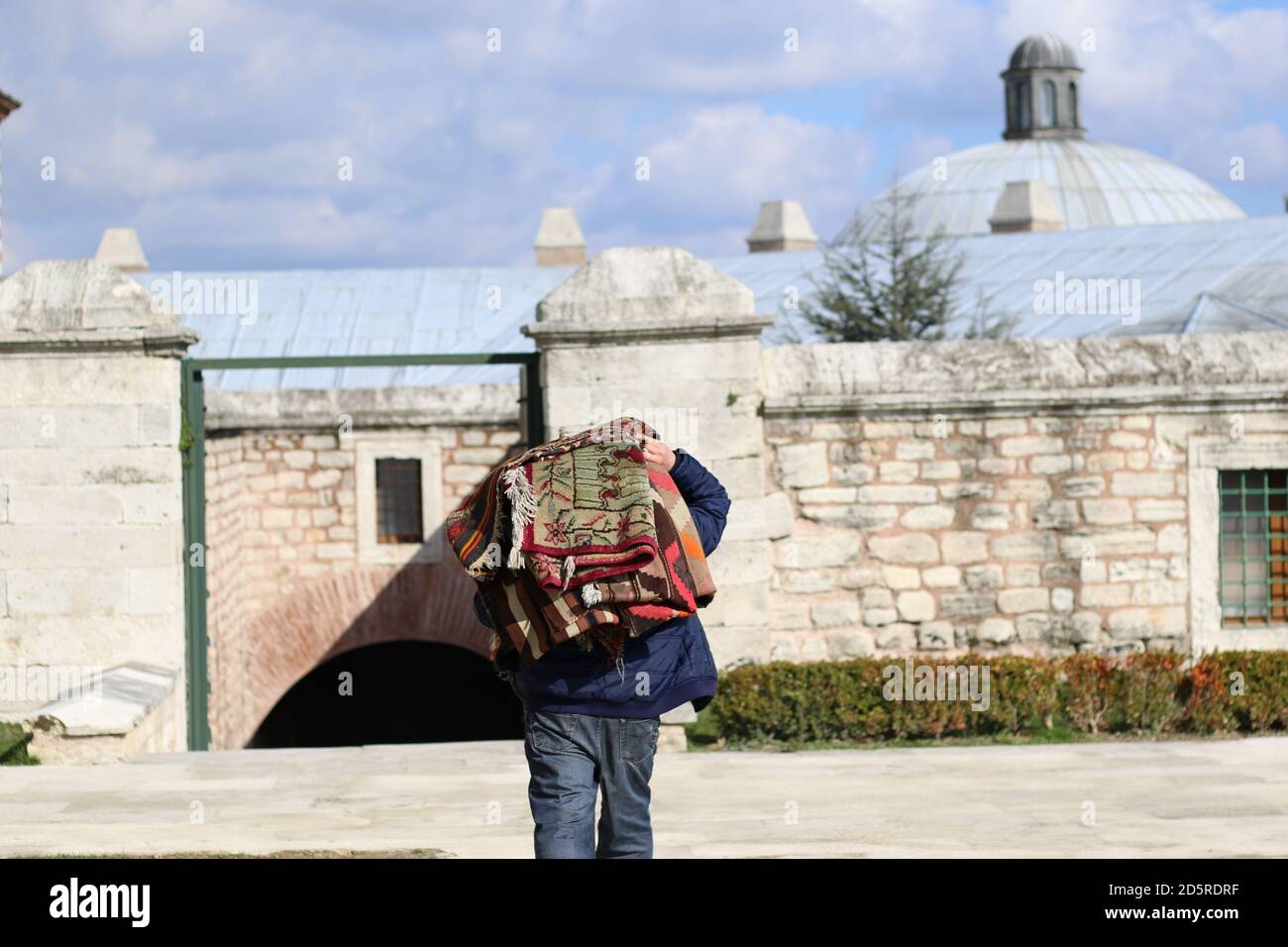 workingman carrying a lot of carpets Stock Photo - Alamy