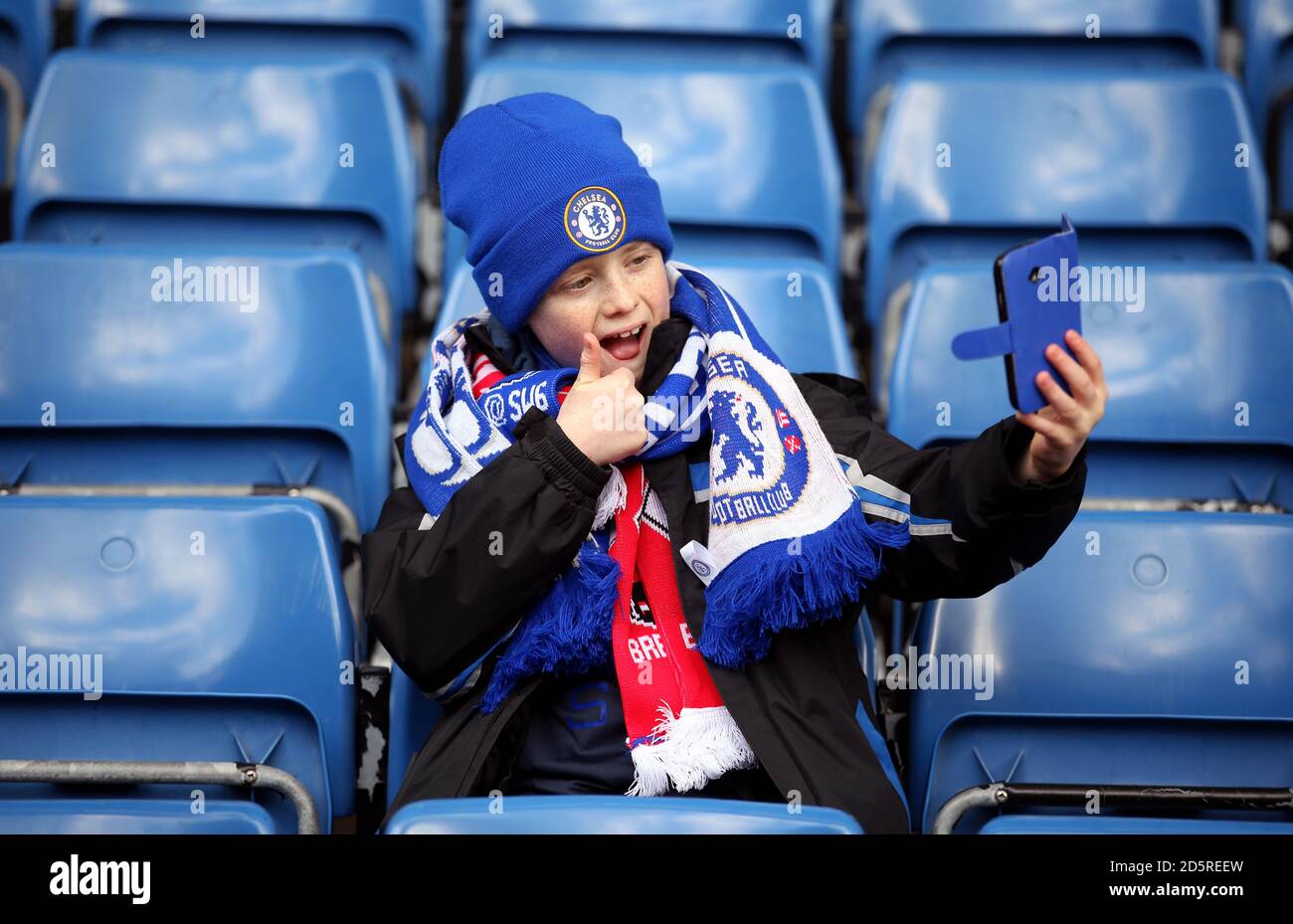 A young Chelsea fan poses for a selfie in the stands before the game ...