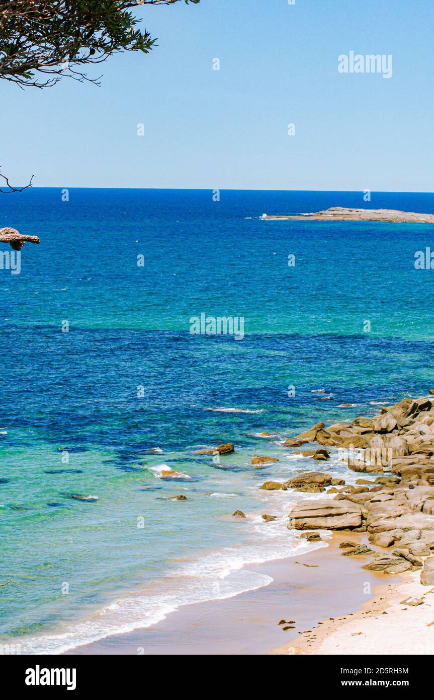 Vertical shot of a shore covered in rocks surrounded by the sea under ...
