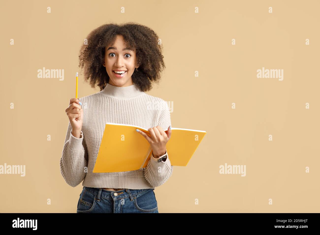 Happy millennial african american woman with open mouth holds notepad ...