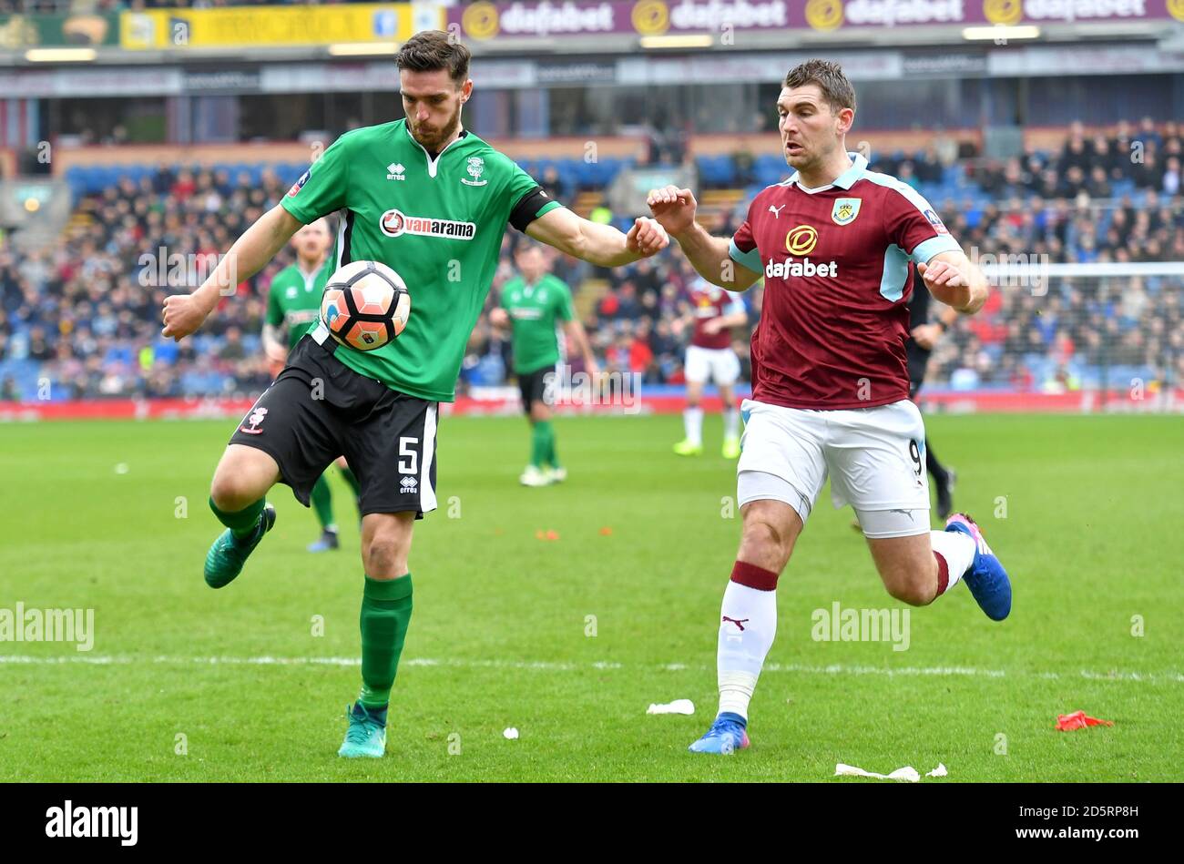 Lincoln City's Luke Waterfall (left) and Burnley's Sam Vokes battle for ...
