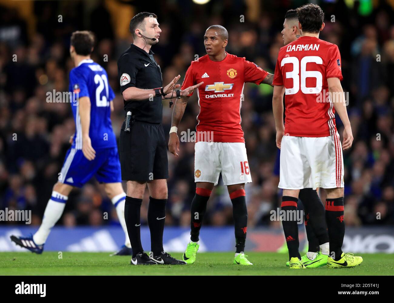 Manchester United's Ashley Young (centre) speaks with match referee ...