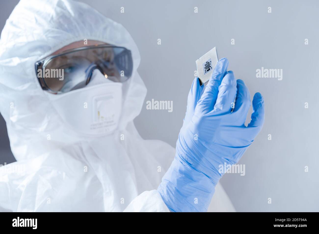 Close-up view on a new semiconductor microchip in gloved hand of ...