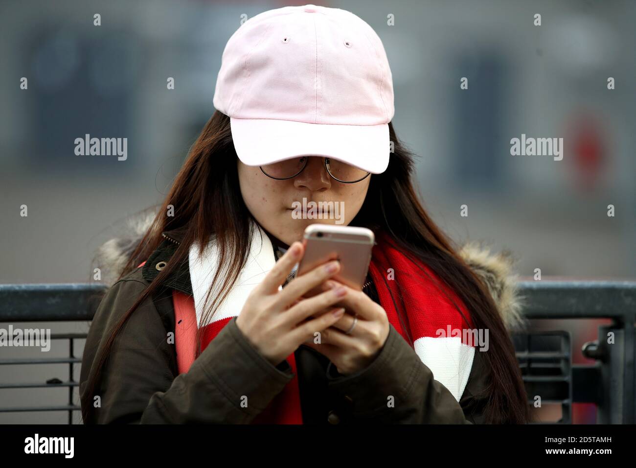 An Arsenal fan using a mobile phone outside the ground before kick-off ...