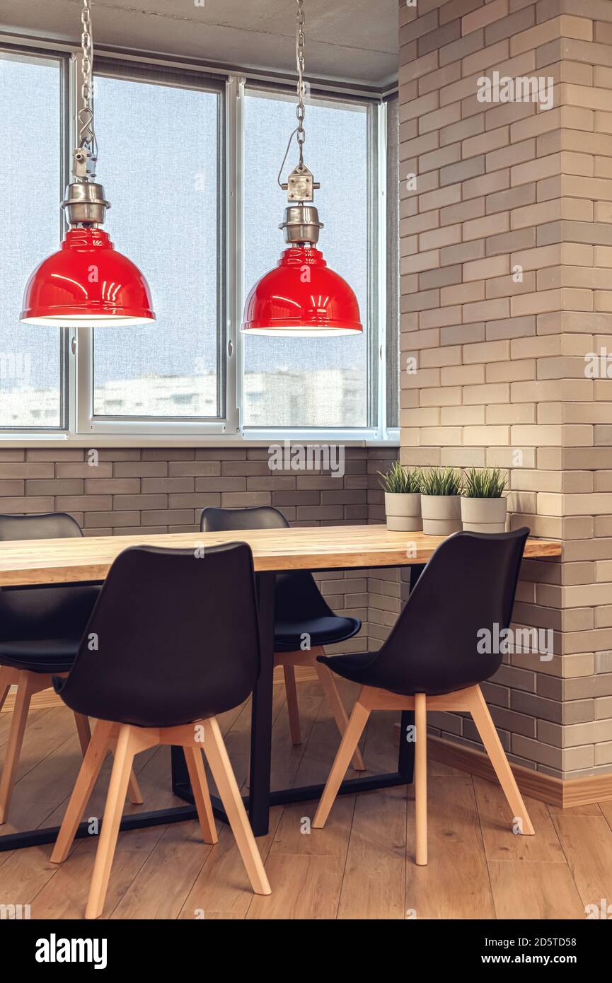 Dining area in warm colors with two red lamps over, the wooden table ...