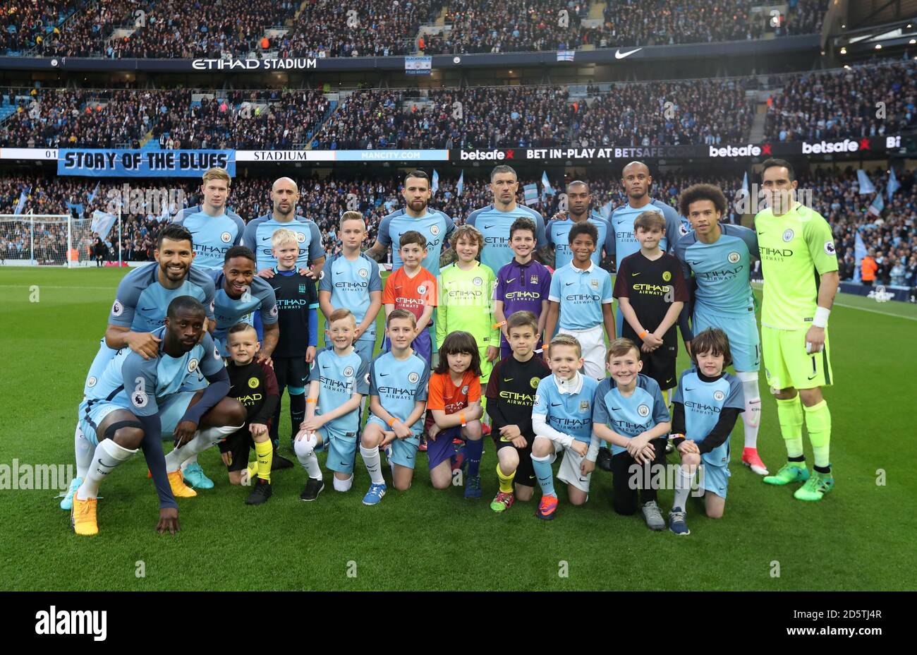 The Manchester City starting line up with the match day mascots before ...