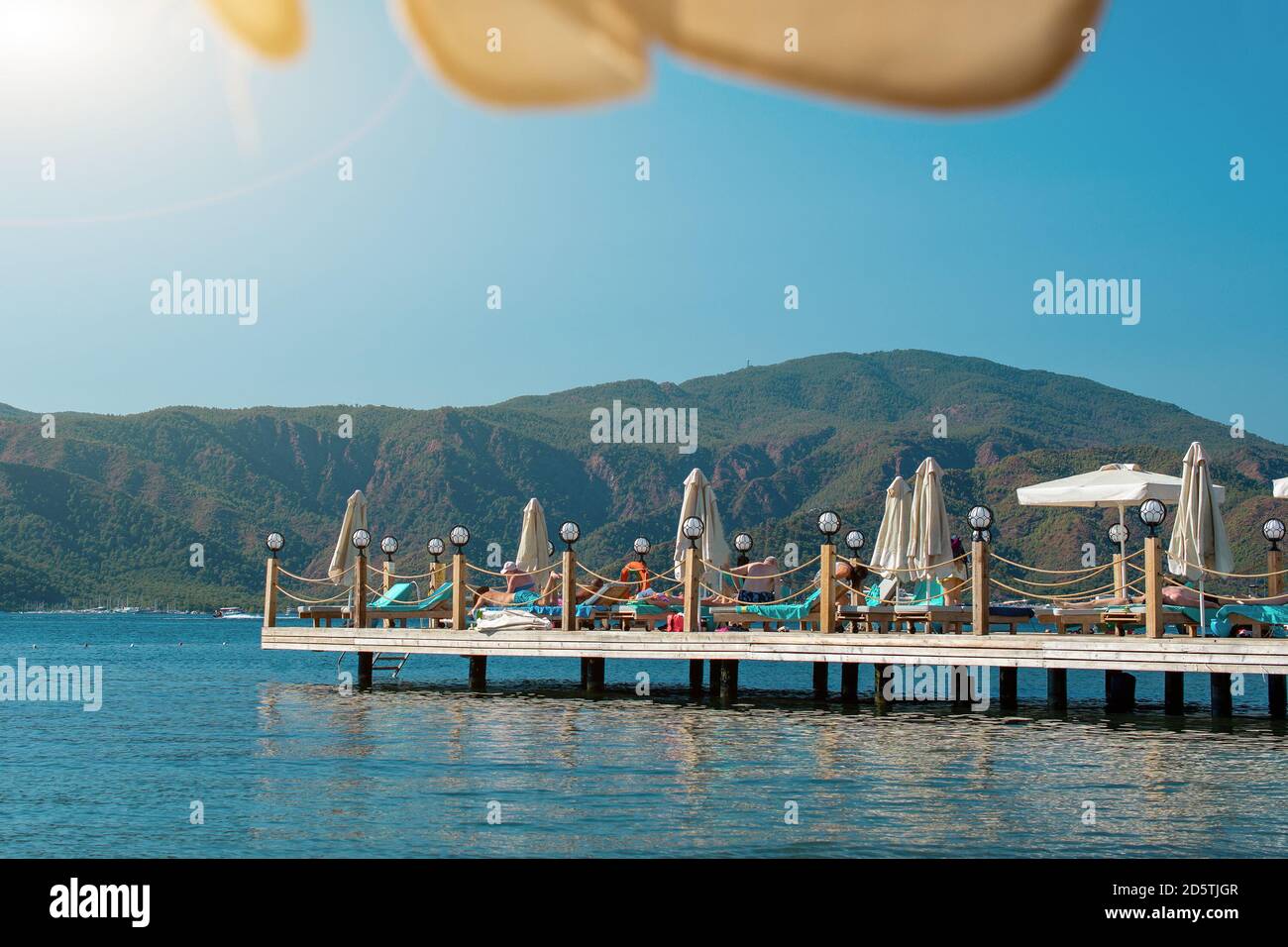 People are stand and lie on the on platform in the sea. platform are ...