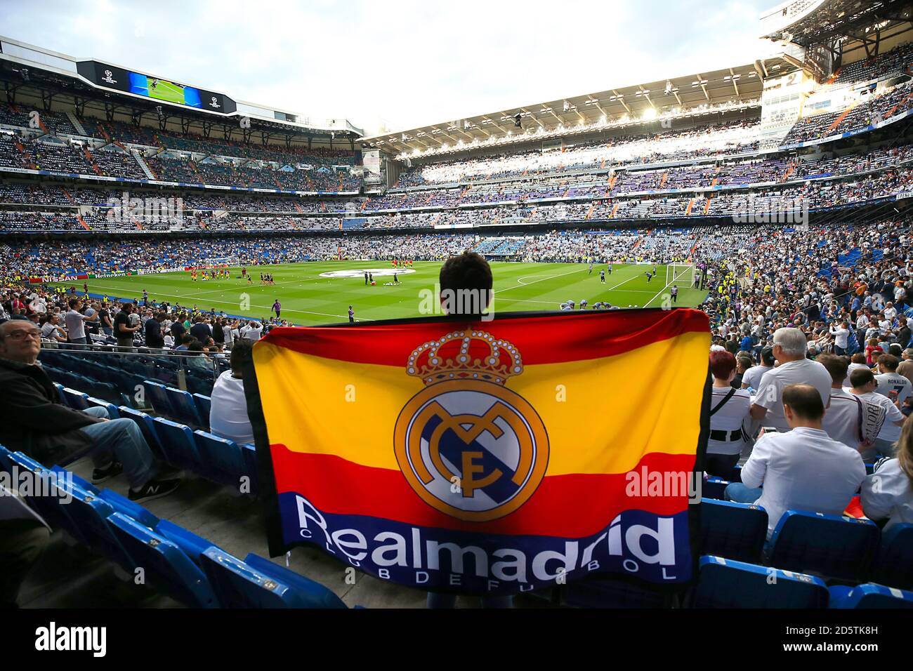 A Real Madrid fan holds a flag in the stands as the teams warm up prior ...