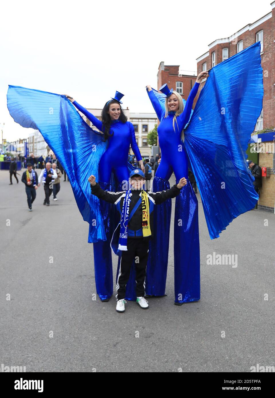 Entertainers on stilts pose with a young Chelsea fan prior to the match ...