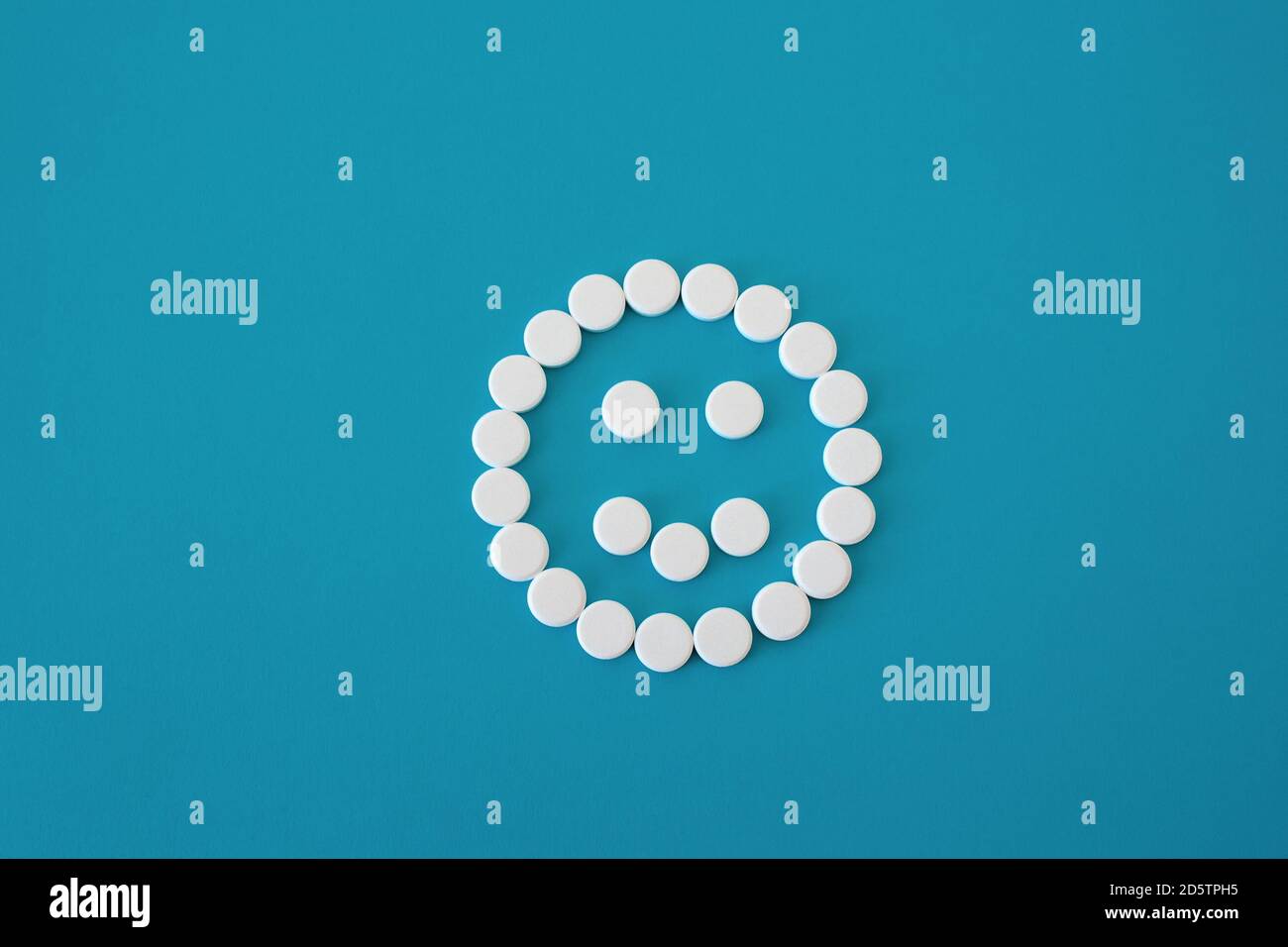 Pills positive smile on blue background, smile is centered , concept ...