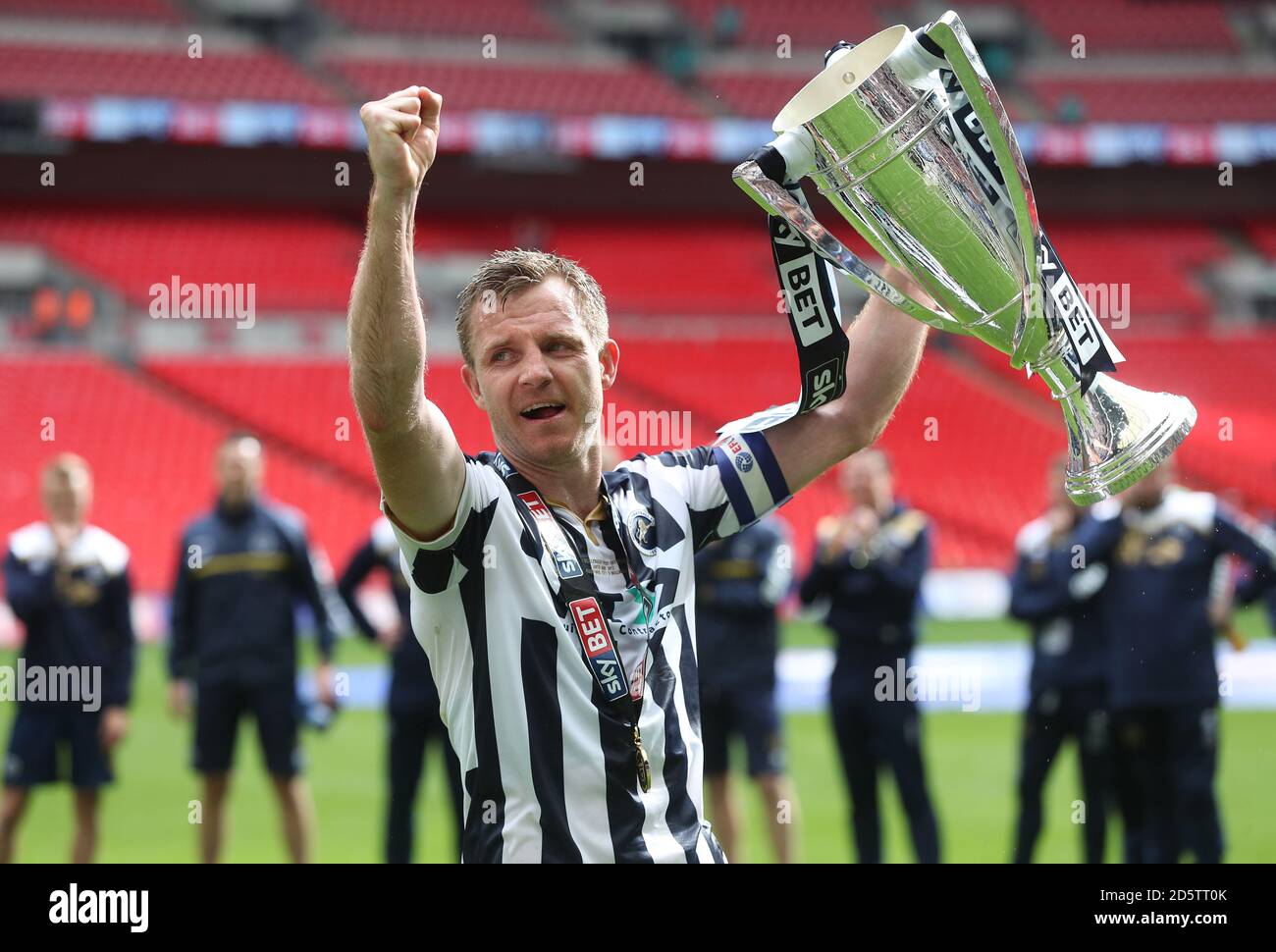 Millwall captain Tony Craig celebrates with the trophy on the pitch ...