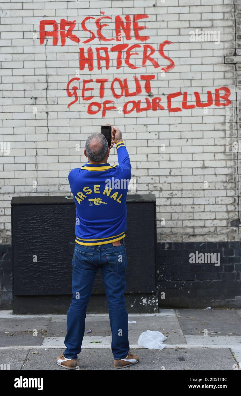 An Arsenal fan takes pictures of graffiti saying 'Arsene haters get out ...