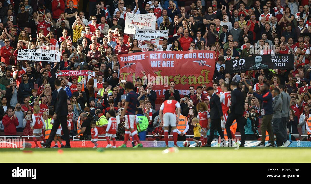 Arsenal fans hold various banners as the players complete a lap of ...