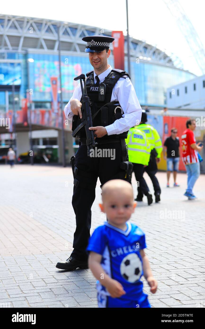 A young Chelsea fan next to an armed police officer on Wembley Way ...