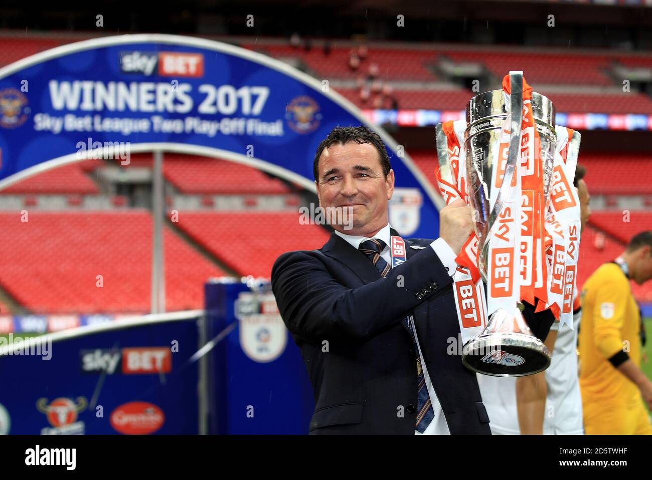 Blackpool manager Gary Bowyer lifts the trophy after the final whistle ...