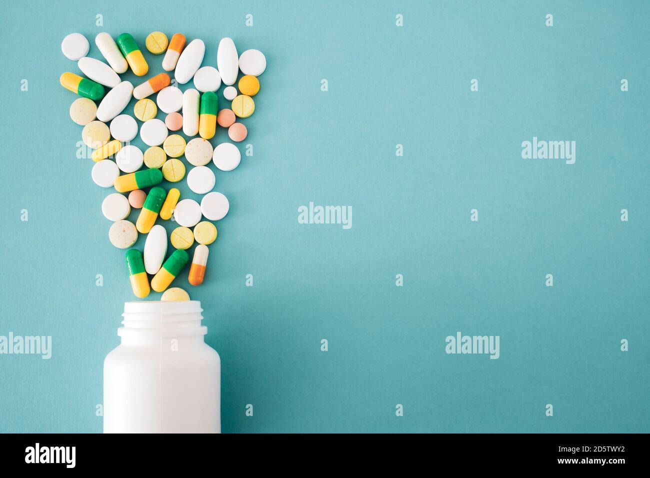 multi-colored tablets and capsules in the form of a cone from a can on ...