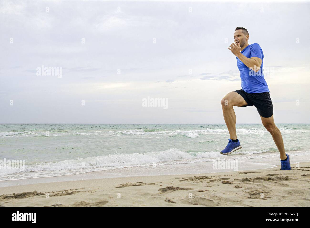 middle-aged man runner run on sandy beach of sea Stock Photo - Alamy