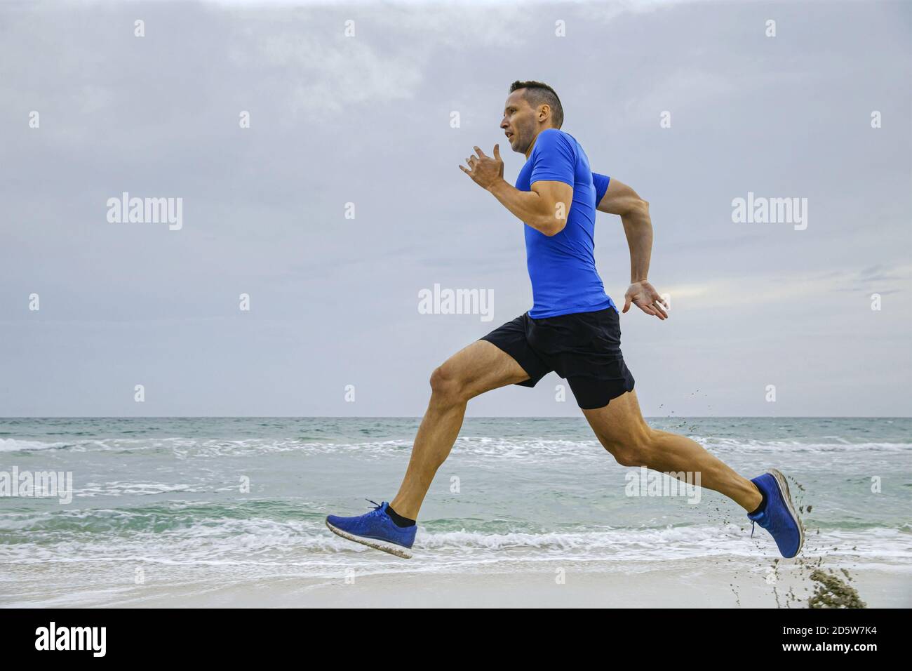 man athlete middle-aged runner running on sea sandy beach Stock Photo ...