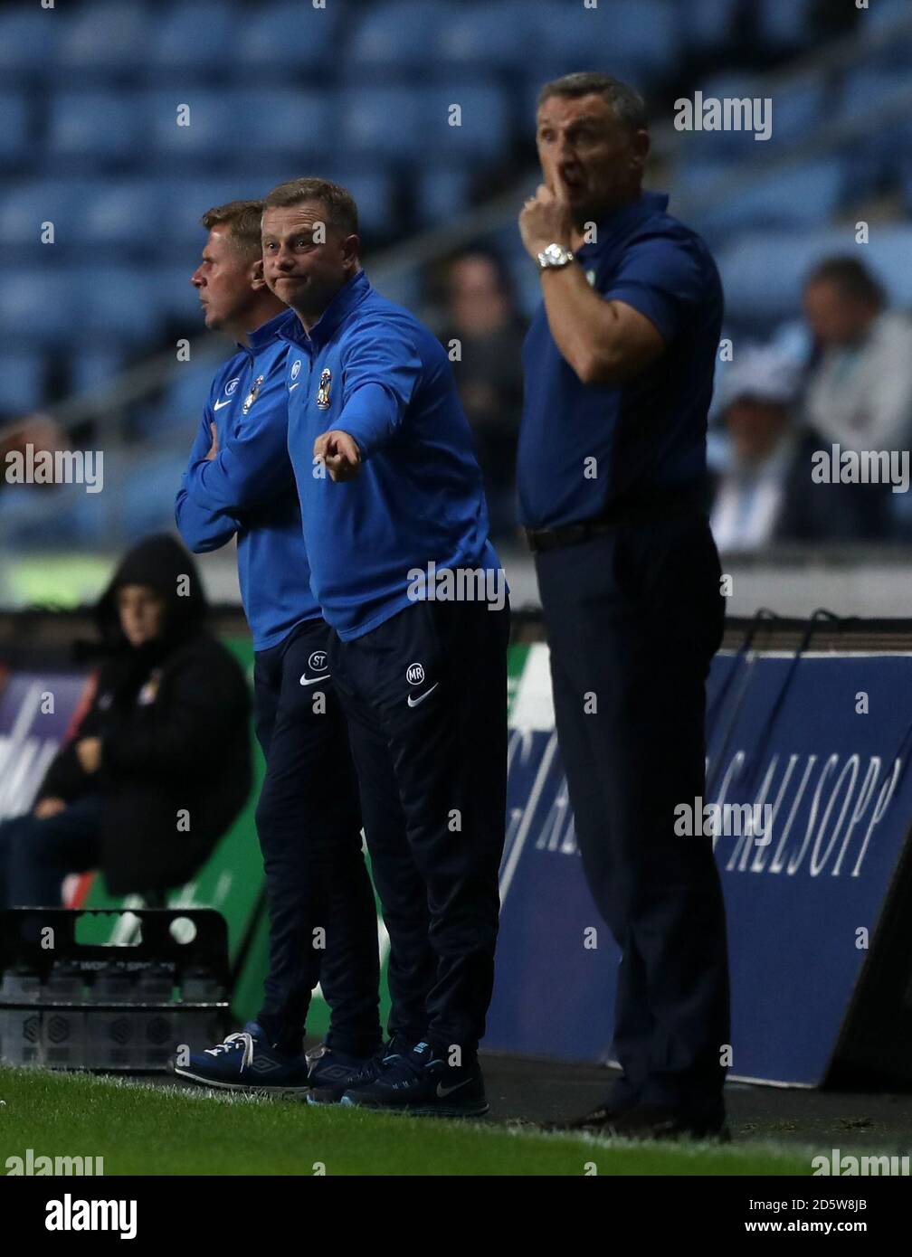 Coventry City manager Mark Robbins (centre) gestures to his players ...