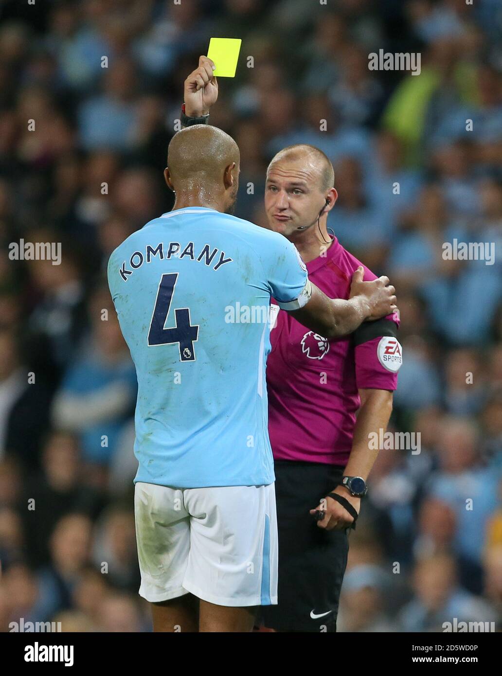 Manchester City's Vincent Kompany is shown the yellow card by referee ...