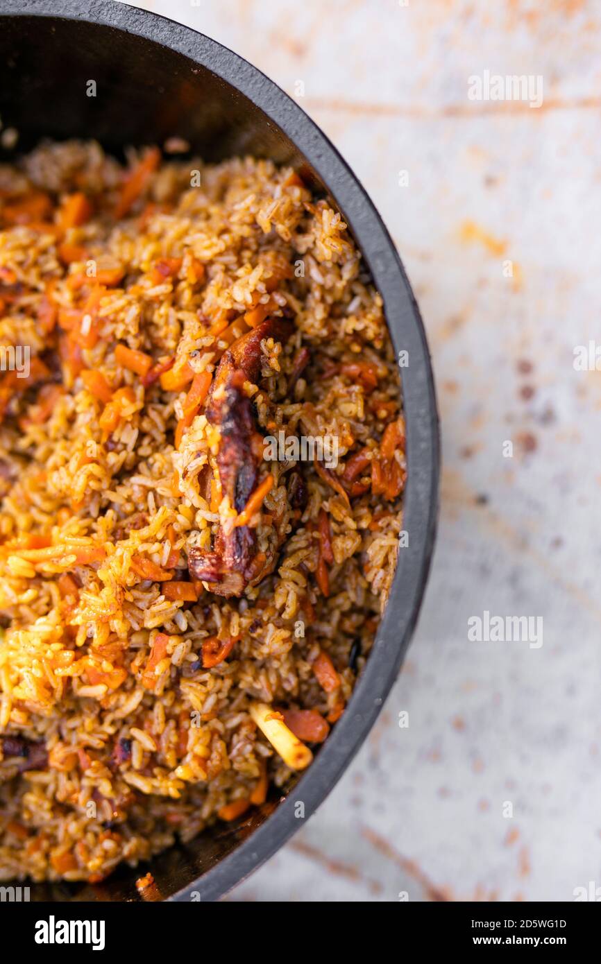 Preparation of raditional armenian pilaf in a cauldron on an open fire ...