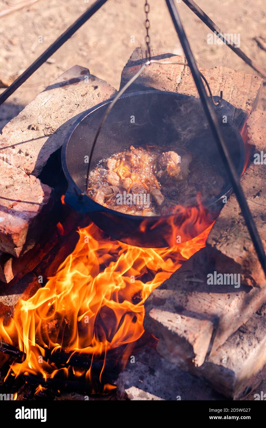 Preparation of raditional armenian pilaf in a cauldron on an open fire ...