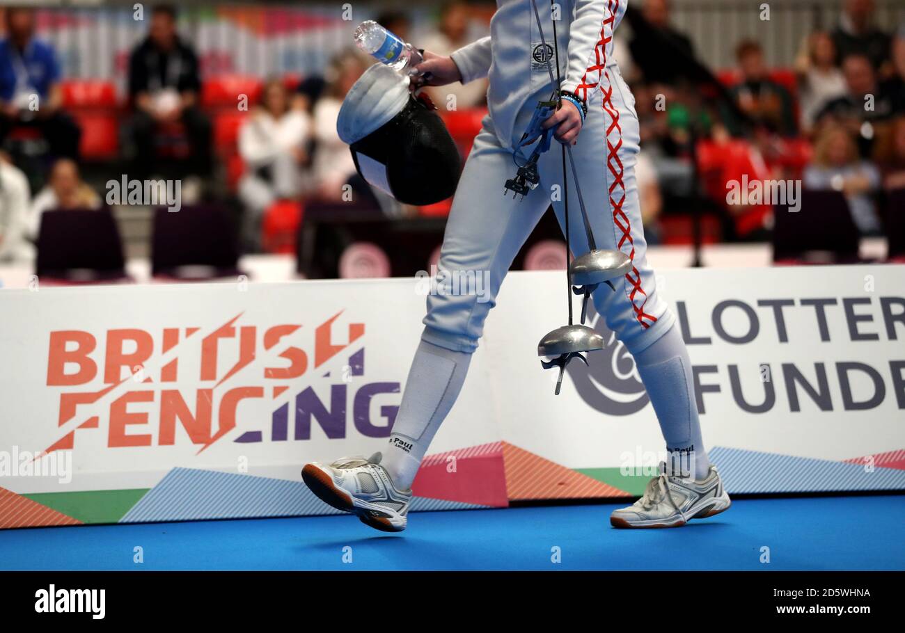 Detail of a competitors legs as they walk past British Fencing signage ...