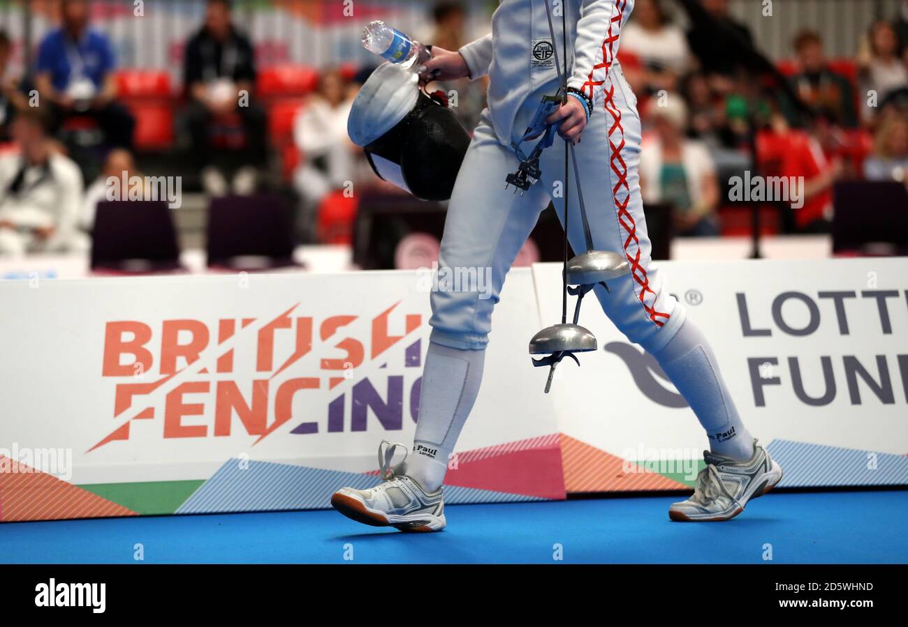 Detail of a competitors legs as they walk past British Fencing signage ...