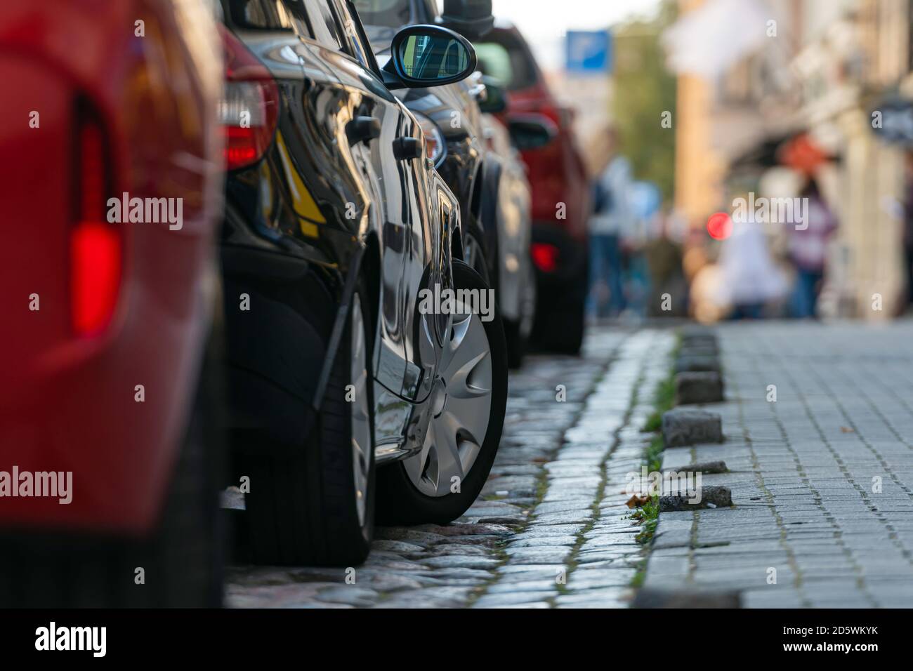 rows of different cars parked along the roadside in crowded city Stock ...
