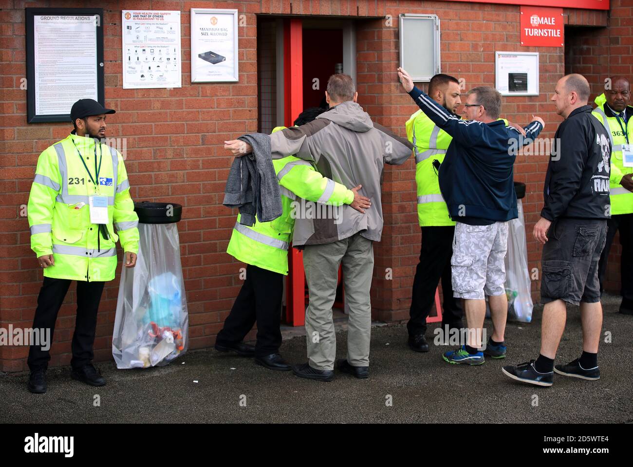 Stewards perform security checks at the turnstiles as fans enter the ...