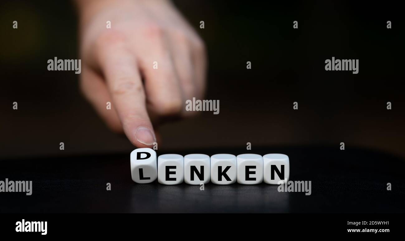 Hand turns dice and changes the German word "Lenken" (guide) to "Denken ...