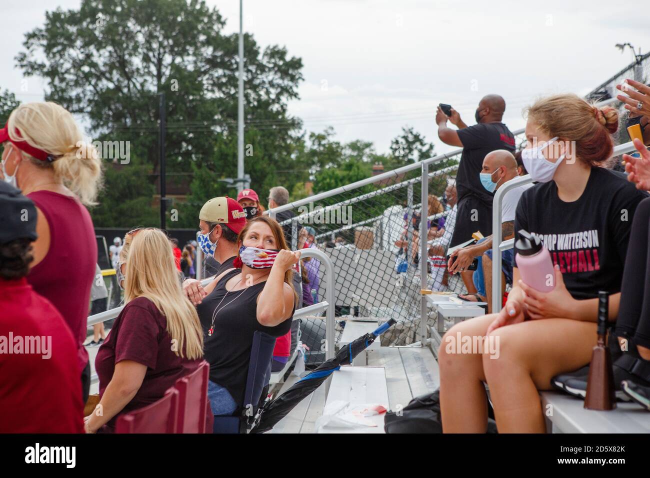 A woman spectator sits in a crowd on bleachers wearing Eagle mask Stock ...