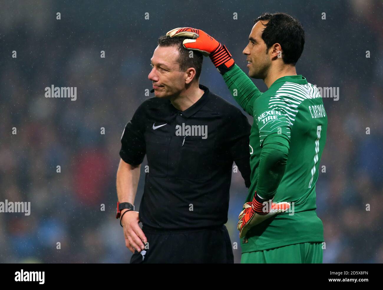 Manchester City goalkeeper Claudio Bravo holds the head of referee ...