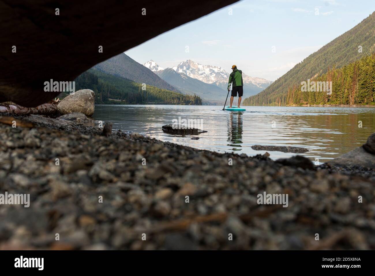 Traveling man on paddleboard on lake Stock Photo - Alamy