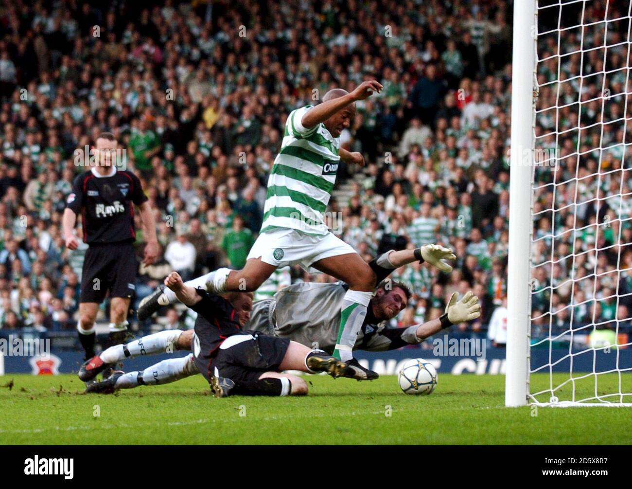 Celtic's Dion Dublin tries to kick the ball towards goal under pressure ...