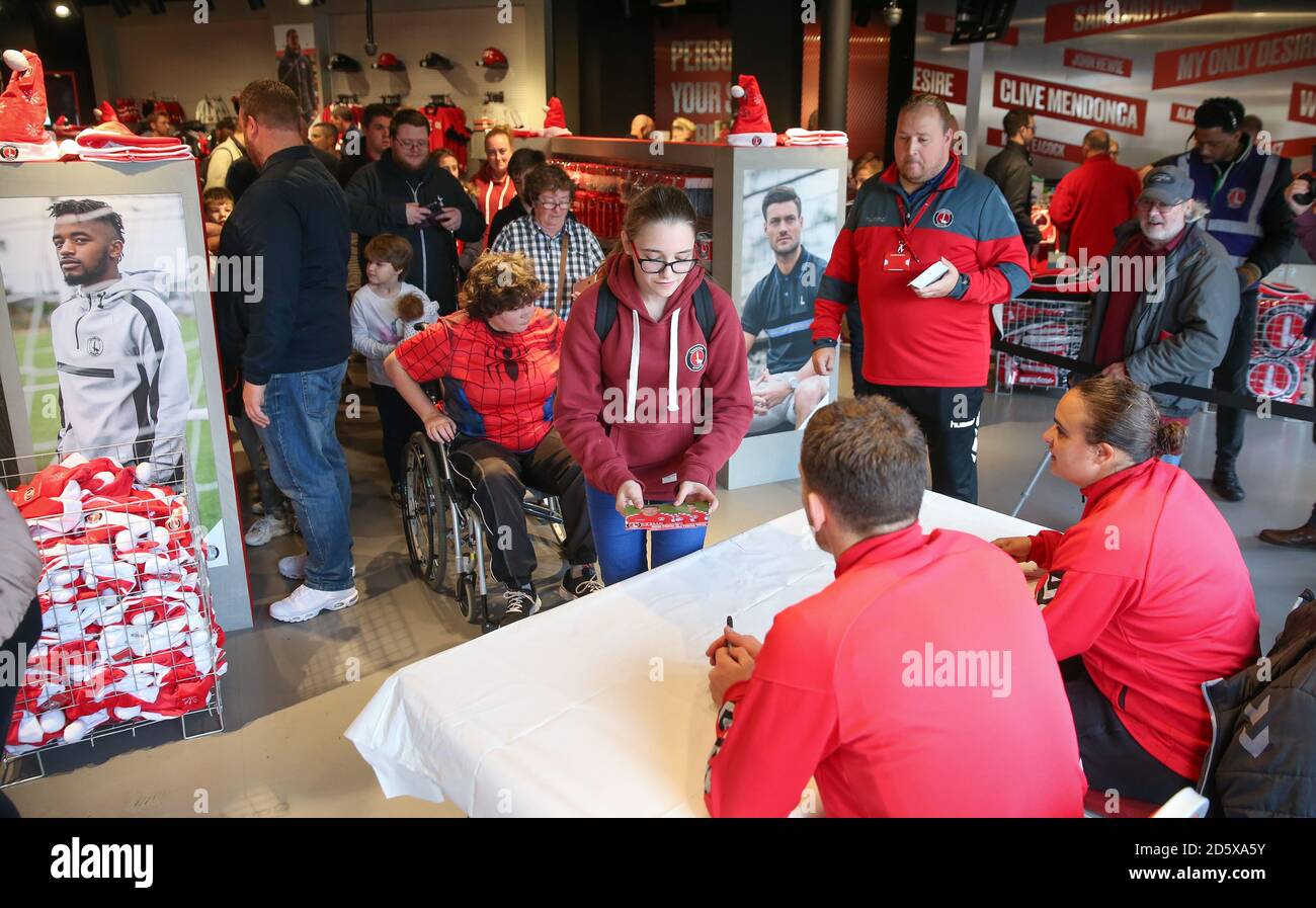 Charlton Athletic's Jason Pearce (left) and Kim Dixson sign autographs ...