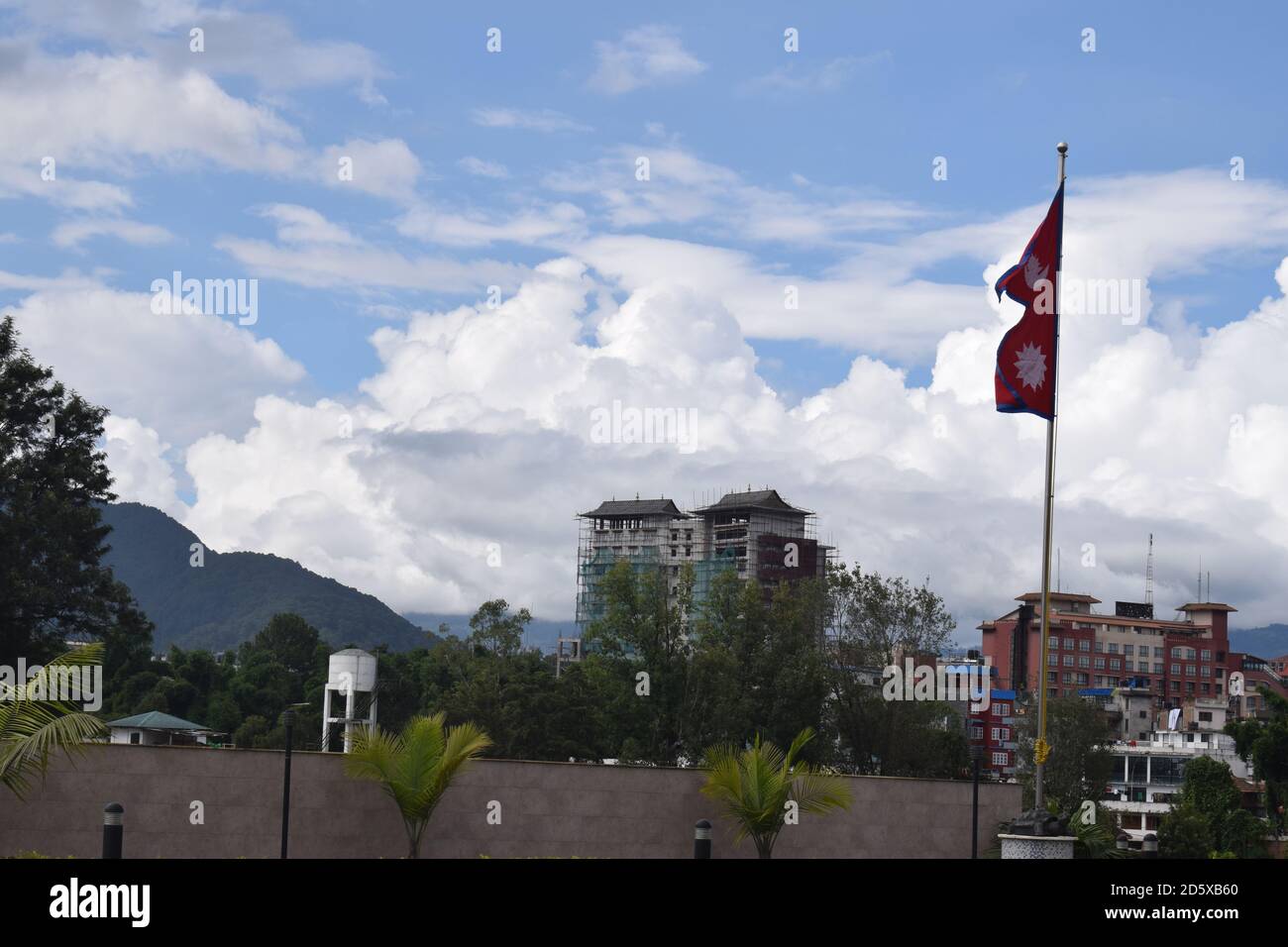 Nepal's National Flag ( Chandra Surya Flag ) among the blue cloudy sky ...